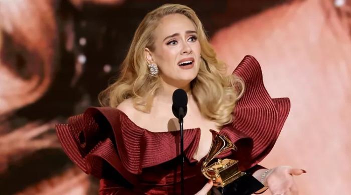 Adele raises trophy for solo performance: 'Here I’m crying'